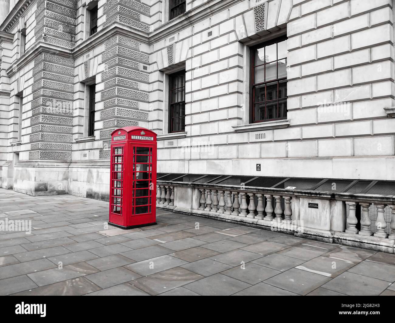 A selective color shot of a traditional red phone booth in London, UK ...