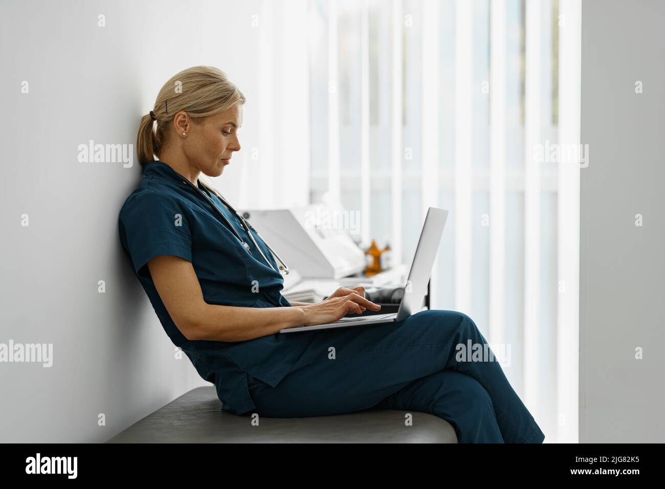 Female healthcare worker using laptop while working at doctor's office ...