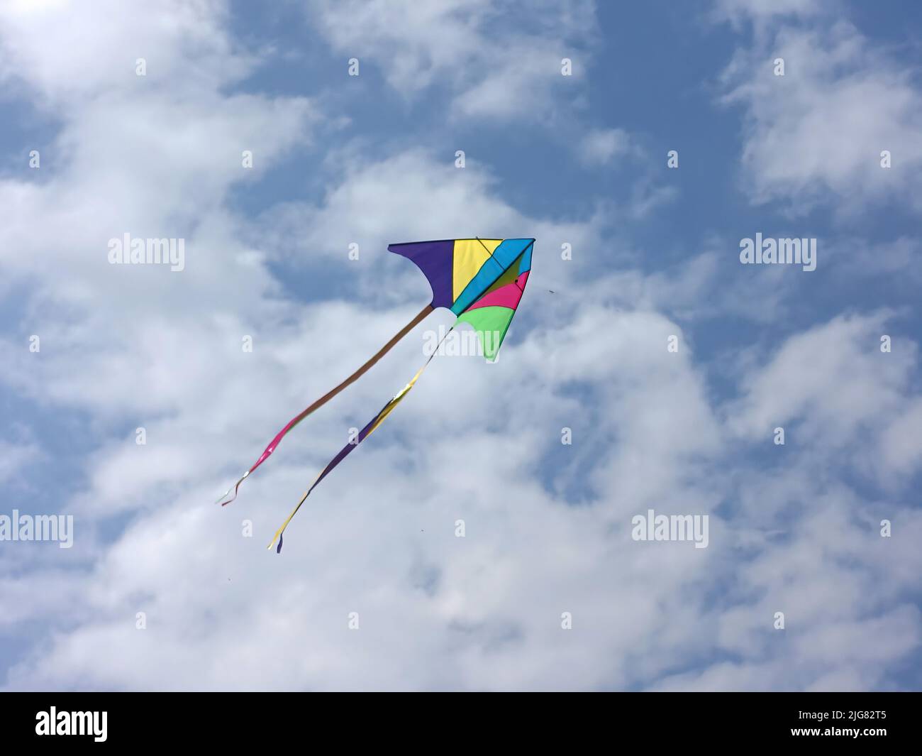 A low angle shot of a colorful kite floating in the cloudy sky Stock ...