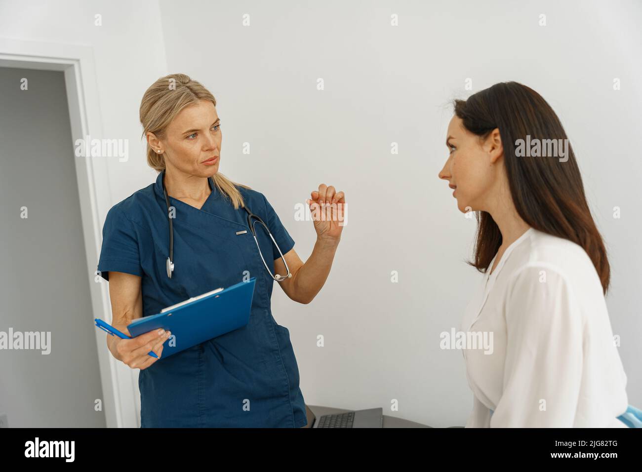 Therapist conducts a preventive examination of a woman in her office in ...