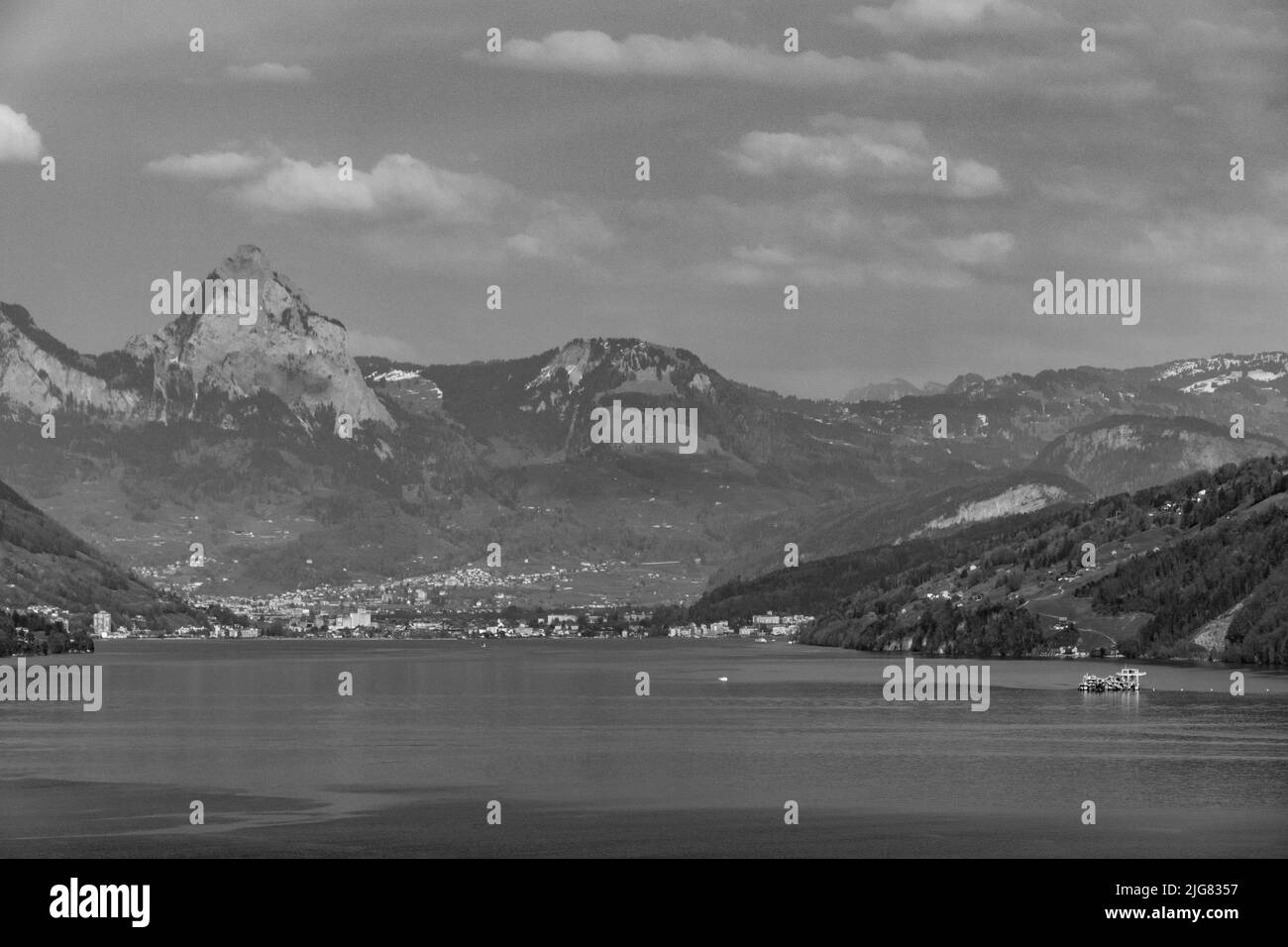 A beautiful grayscale shot of mountains by Lake Lucerne on a sunny day ...
