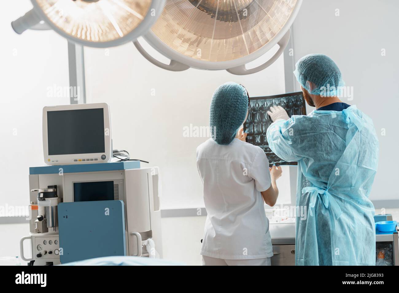 Doctor and nurse in uniform look and discuss an X-ray or MRI scan of ...