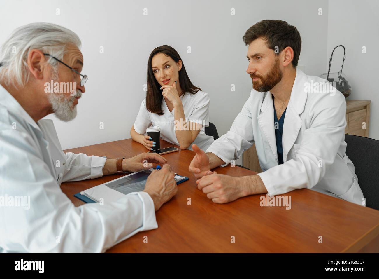 Successful medical doctors are discussing diagnosis during the ... Successful medical doctors are discussing diagnosis during the ...