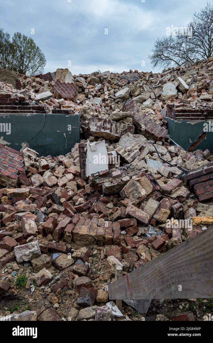a vertical shot of a pile of bricks at the foundation of a demolished ...