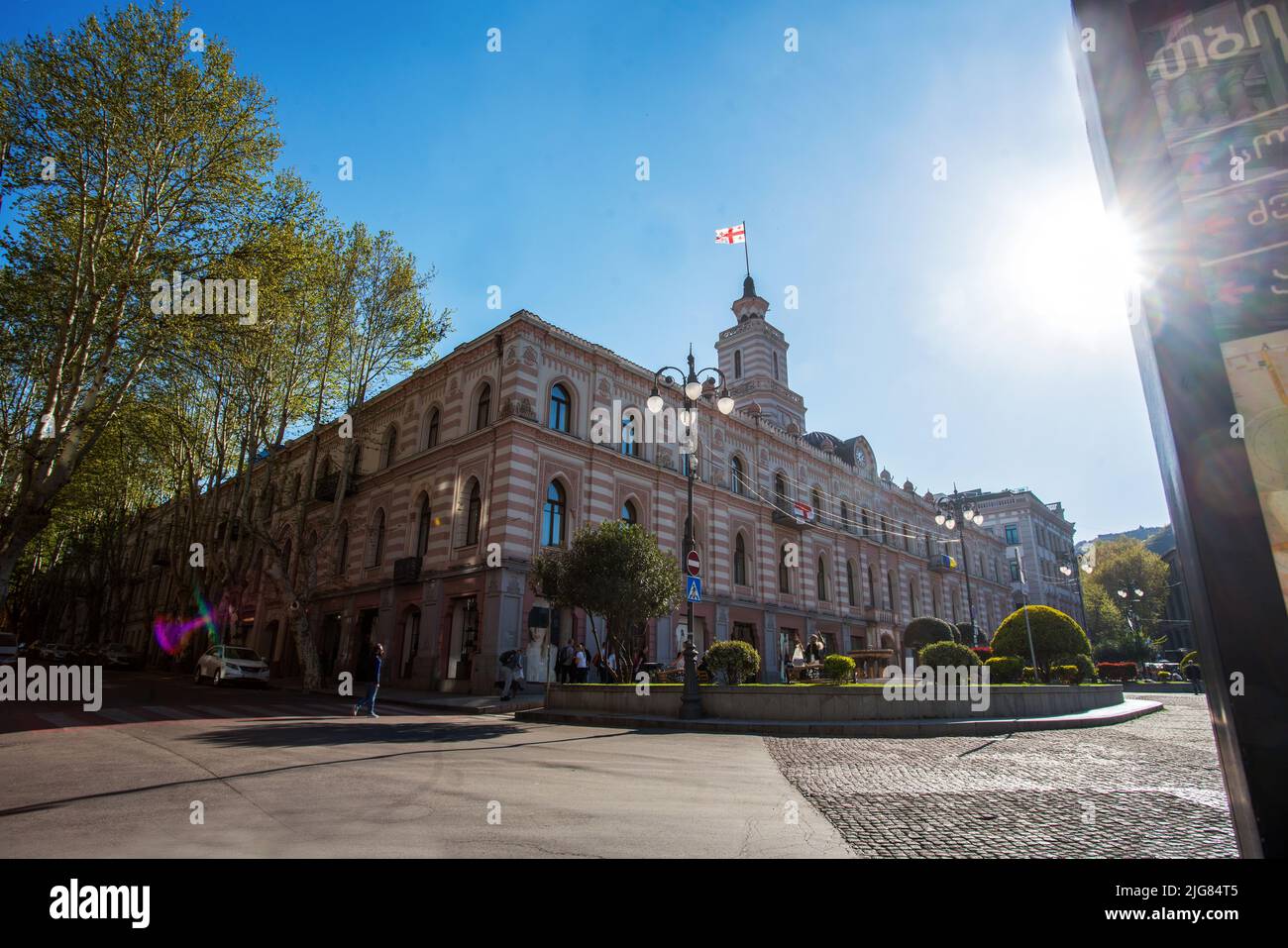 Old building on Republic Square in Tbilisi . People in distance. Flag ...