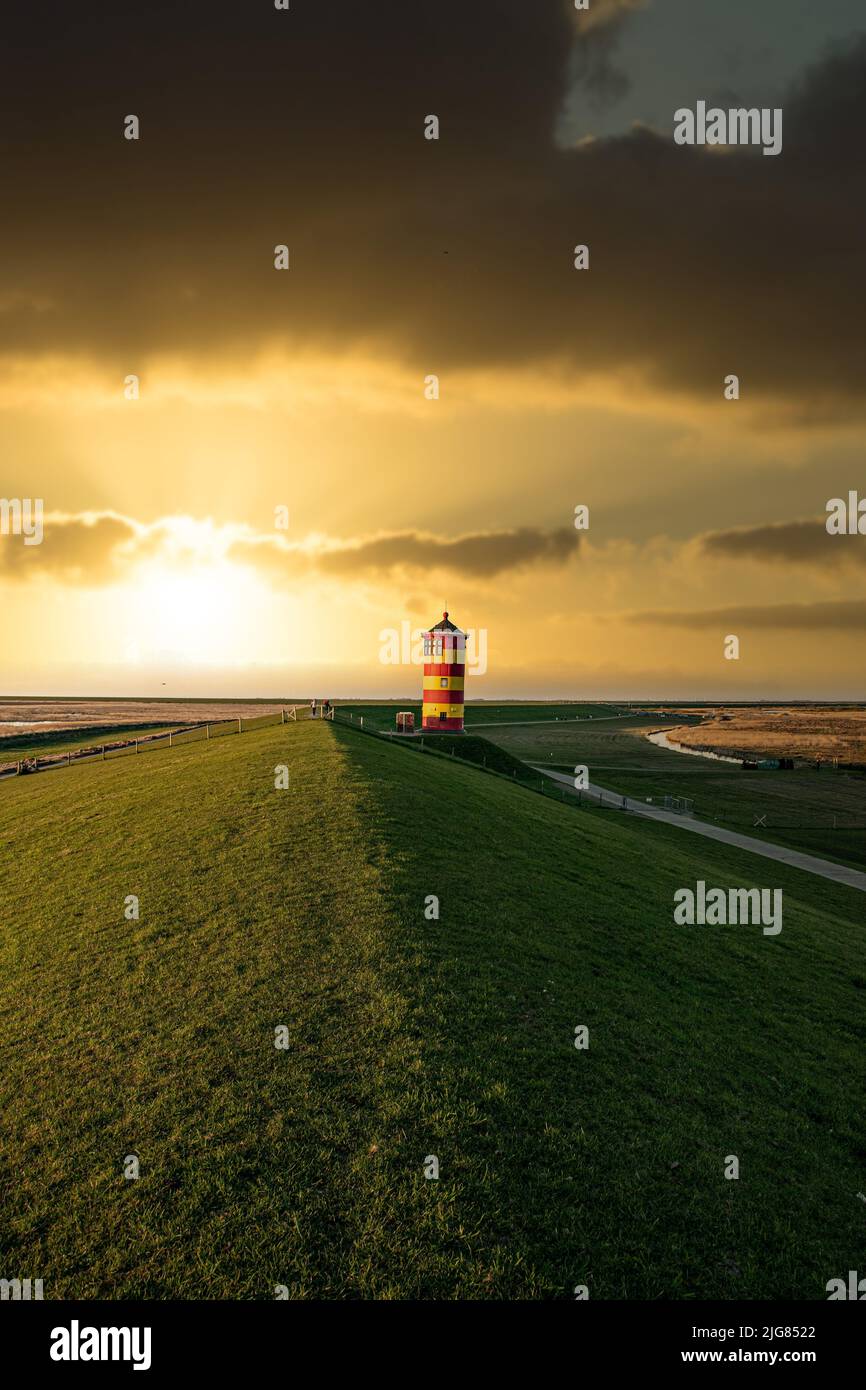 An old lighthouse, greenfield, and coast in Germany during sunset Stock ...