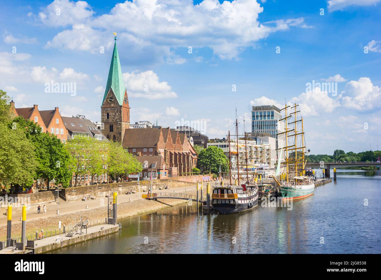 Historic sailing ships and church tower at the Weser river in Bremen ...