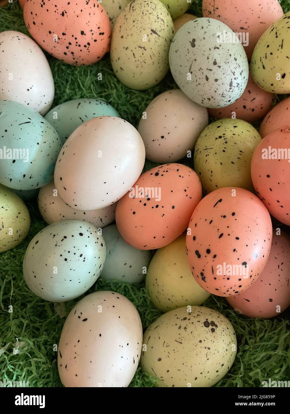 A vertical shot of colorful eggs with black spots for Easter on an ...