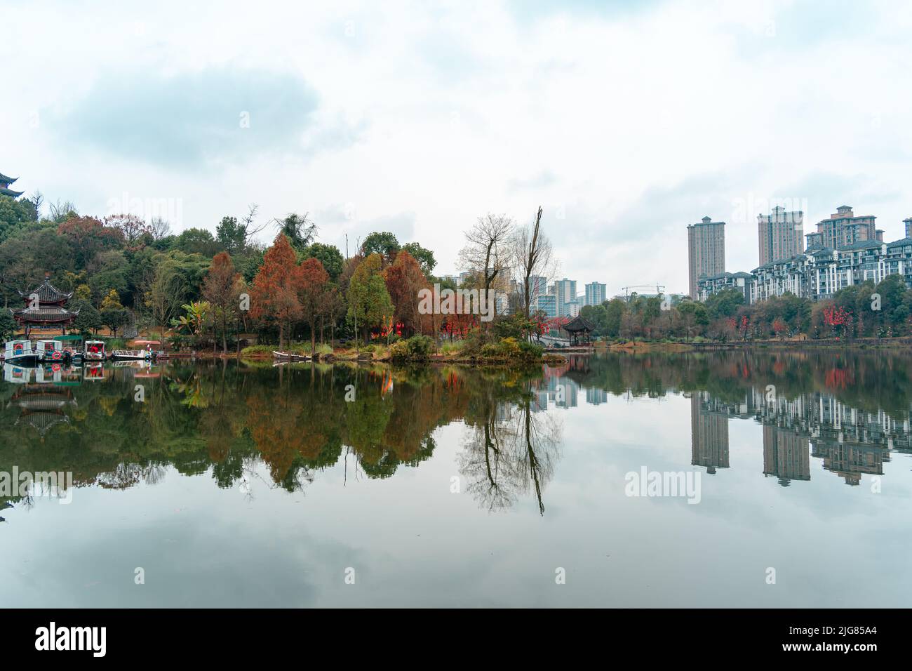 The beautiful view of a lake with a small Chinese pavilion on the shore ...