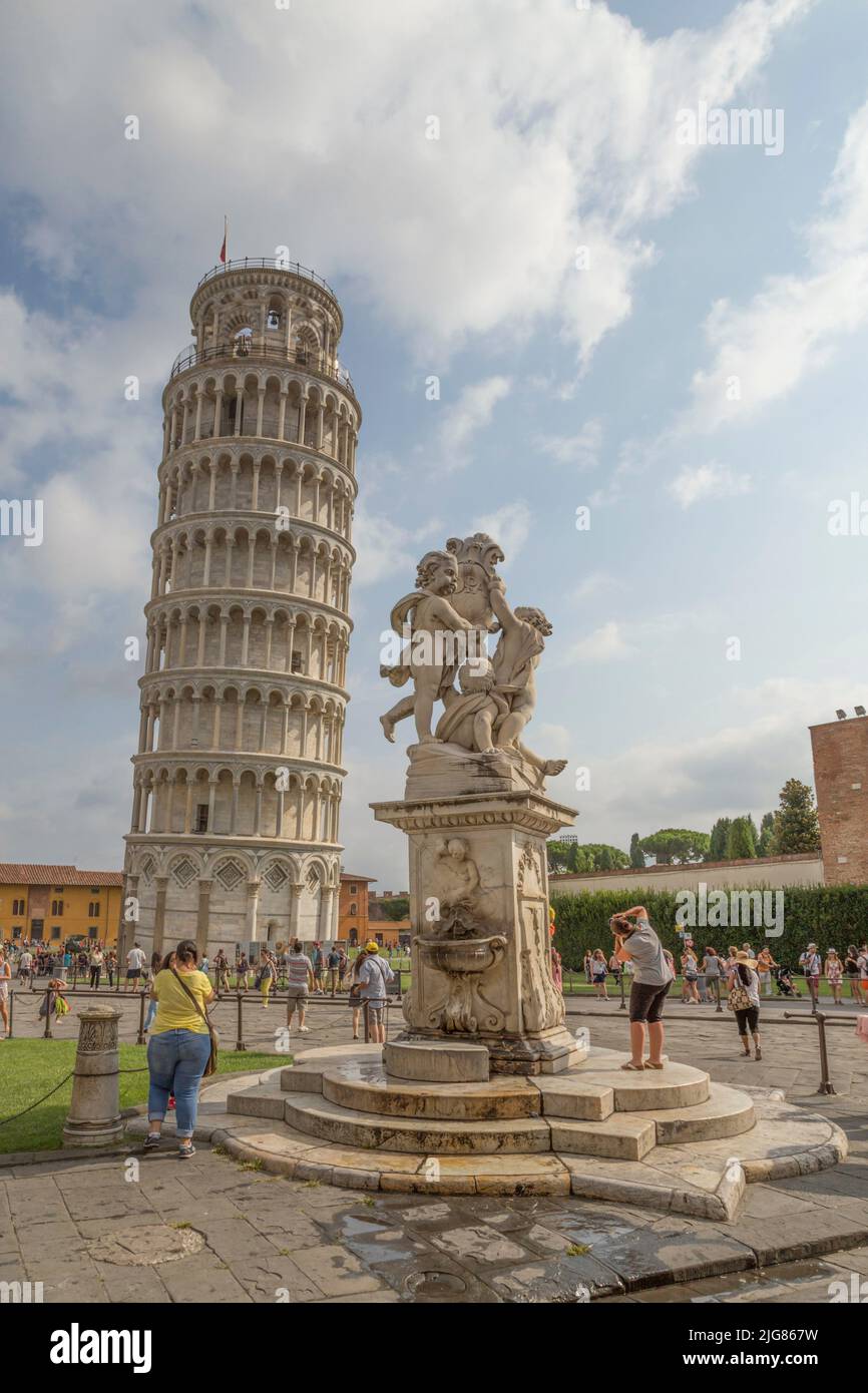 The Leaning Tower of Pisa in the back of a statue surrounded by ...