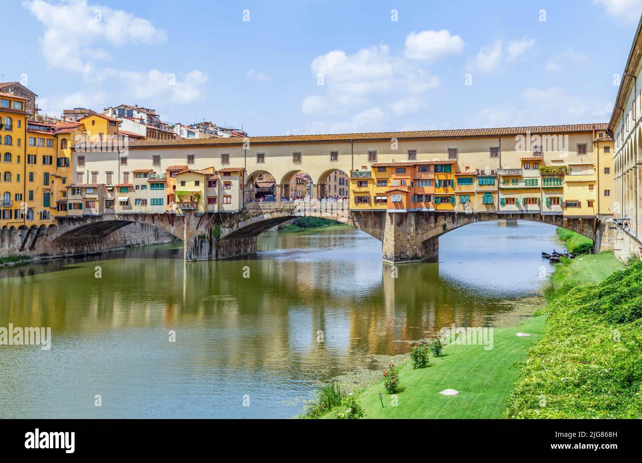A bridge over the river between buildings in Firenze, Italy Stock Photo ...
