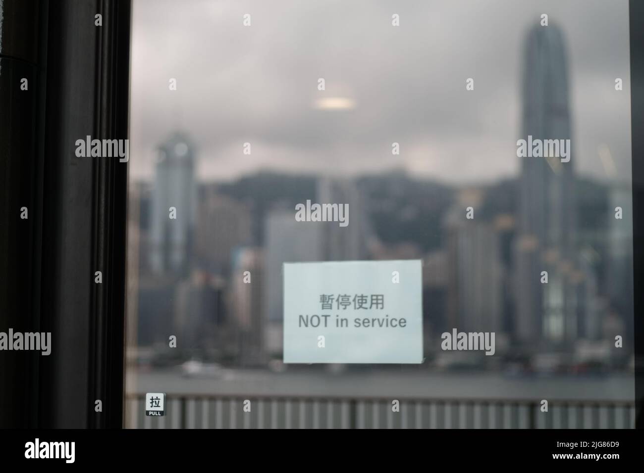 A warning attached on the glass with text "not in service" on the ...