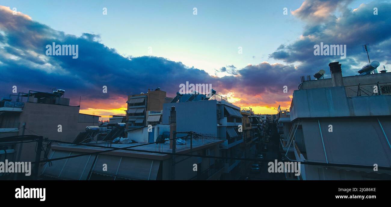 A scenic view of residential buildings with a vibrant sunset in the sky ...