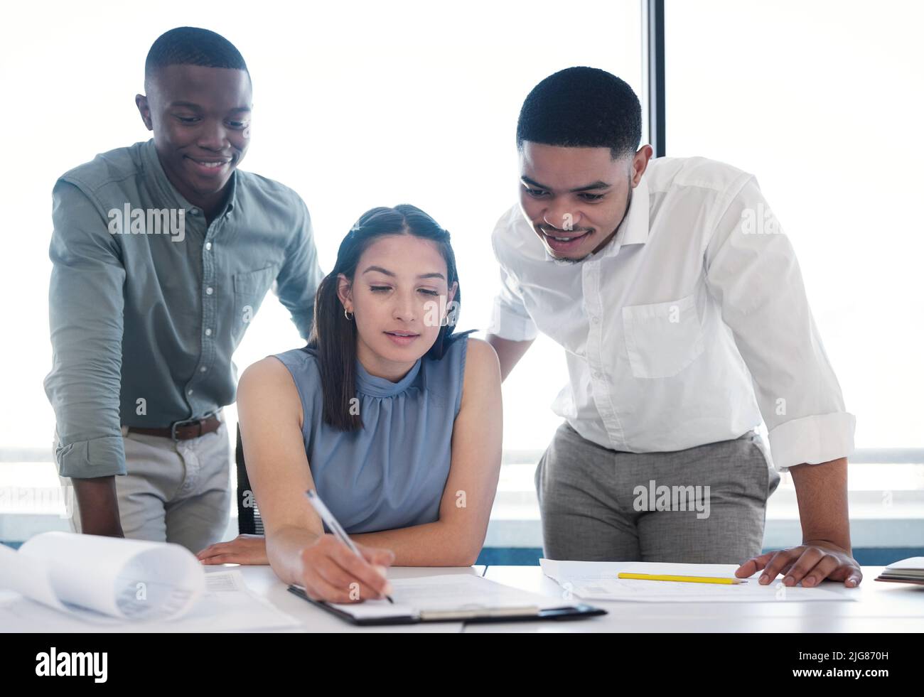 The team that can do it all. Shot of a team of young architects drawing ...