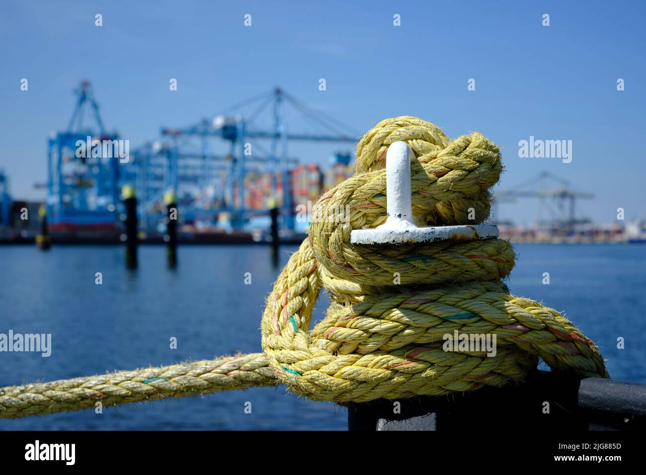 A iron bollard with a tied rope on a quay in the Port of Rotterdam in ...