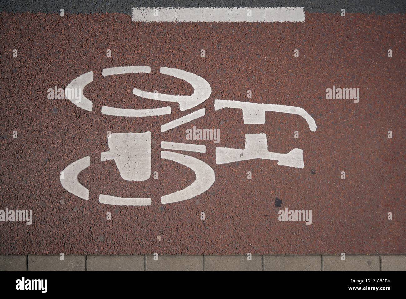 Bike lane with cycle route symbol on the floor. Red path between the ...