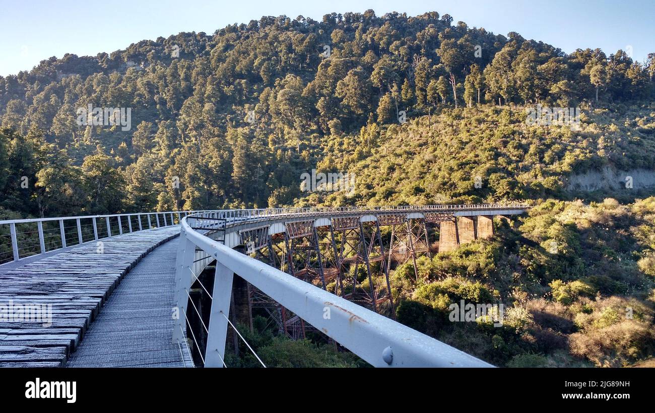 A white bridge leading to the beautiful mountains in summer Stock Photo ...