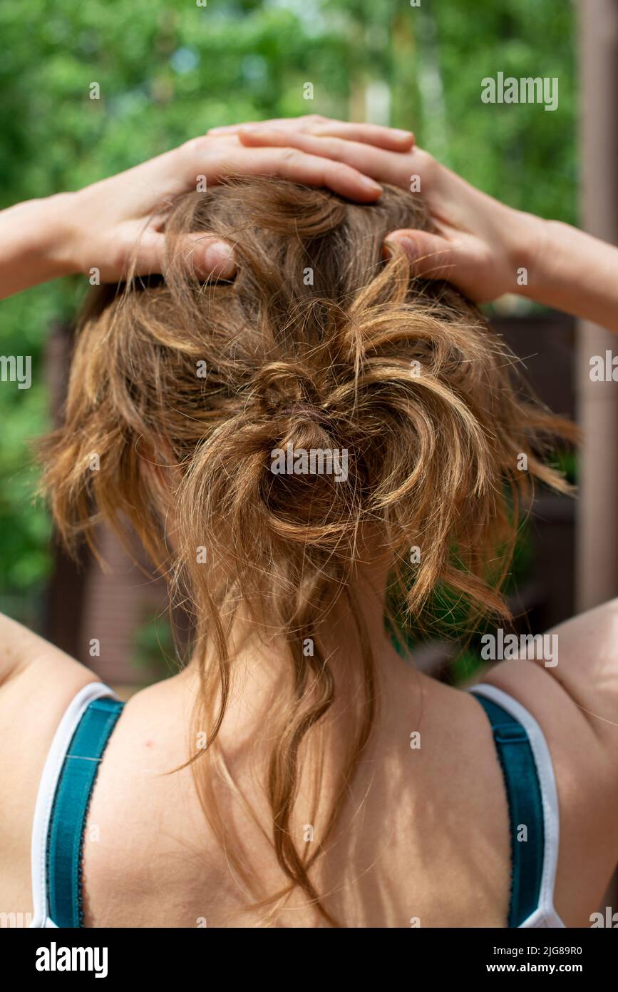 Natural unbrushed hair of a young woman in a messy up do hairstyle ...