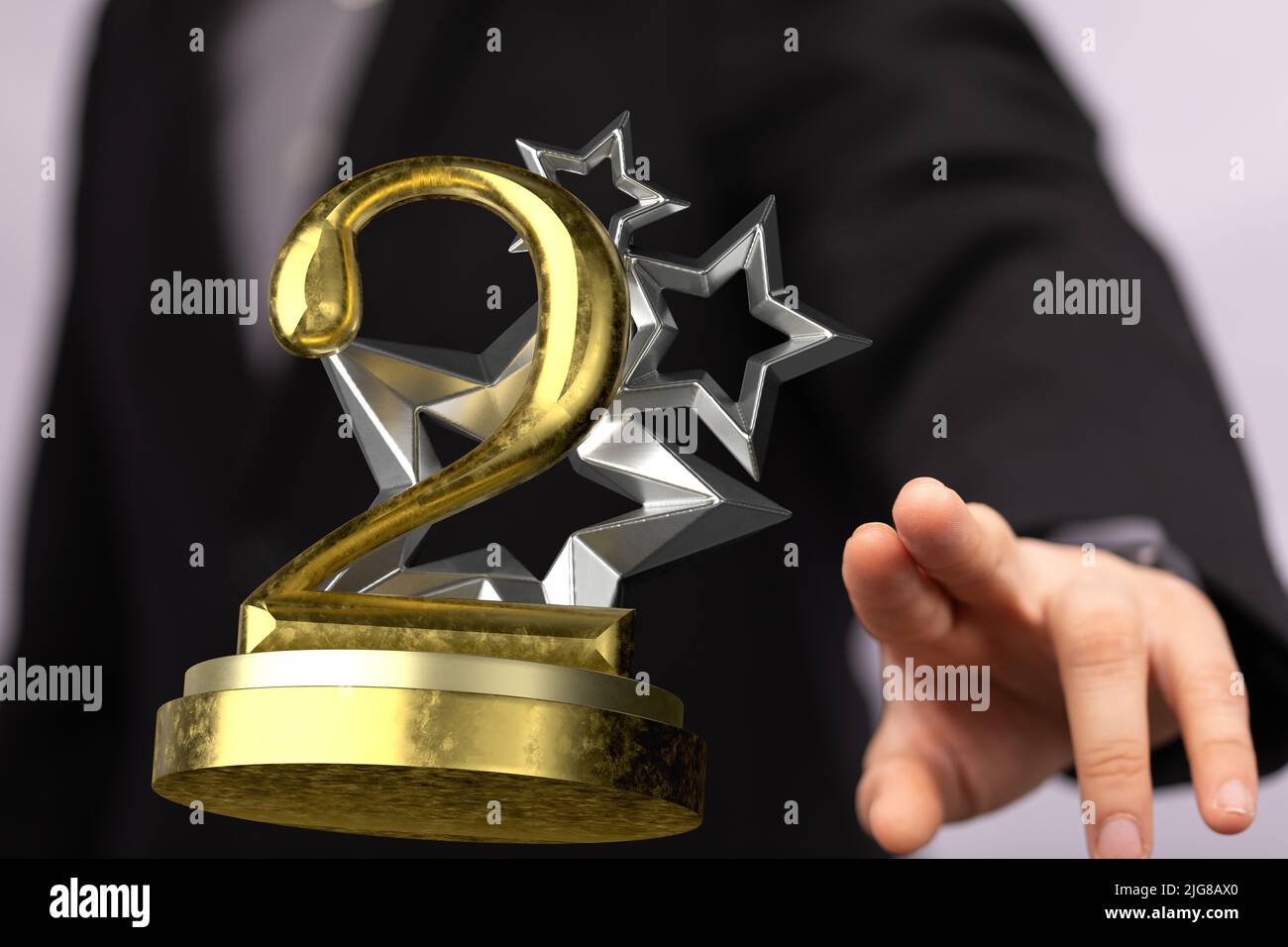 A closeup of two fingers pointing to a trophy award with the number 2 ...