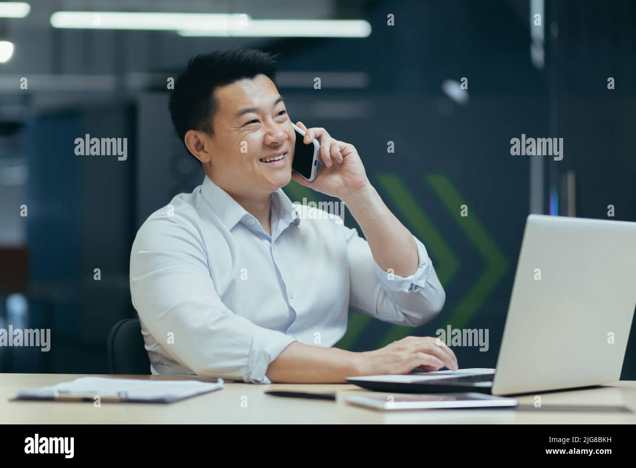 Successful asian entrepreneur working in modern office with laptop ...