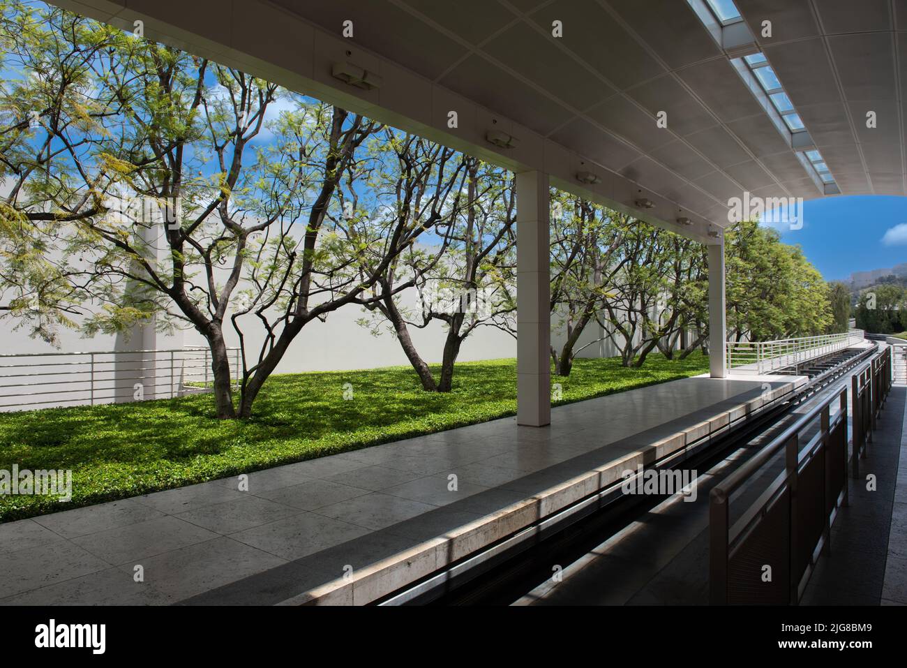 An outdoor monorail platform with trees on the outside in the Getty ...