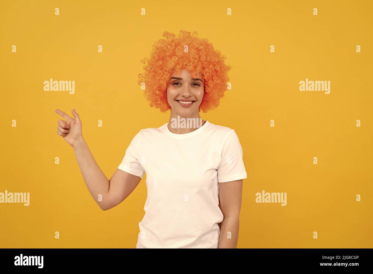 happy freaky woman in curly clown wig pointing finger, gesture and ...