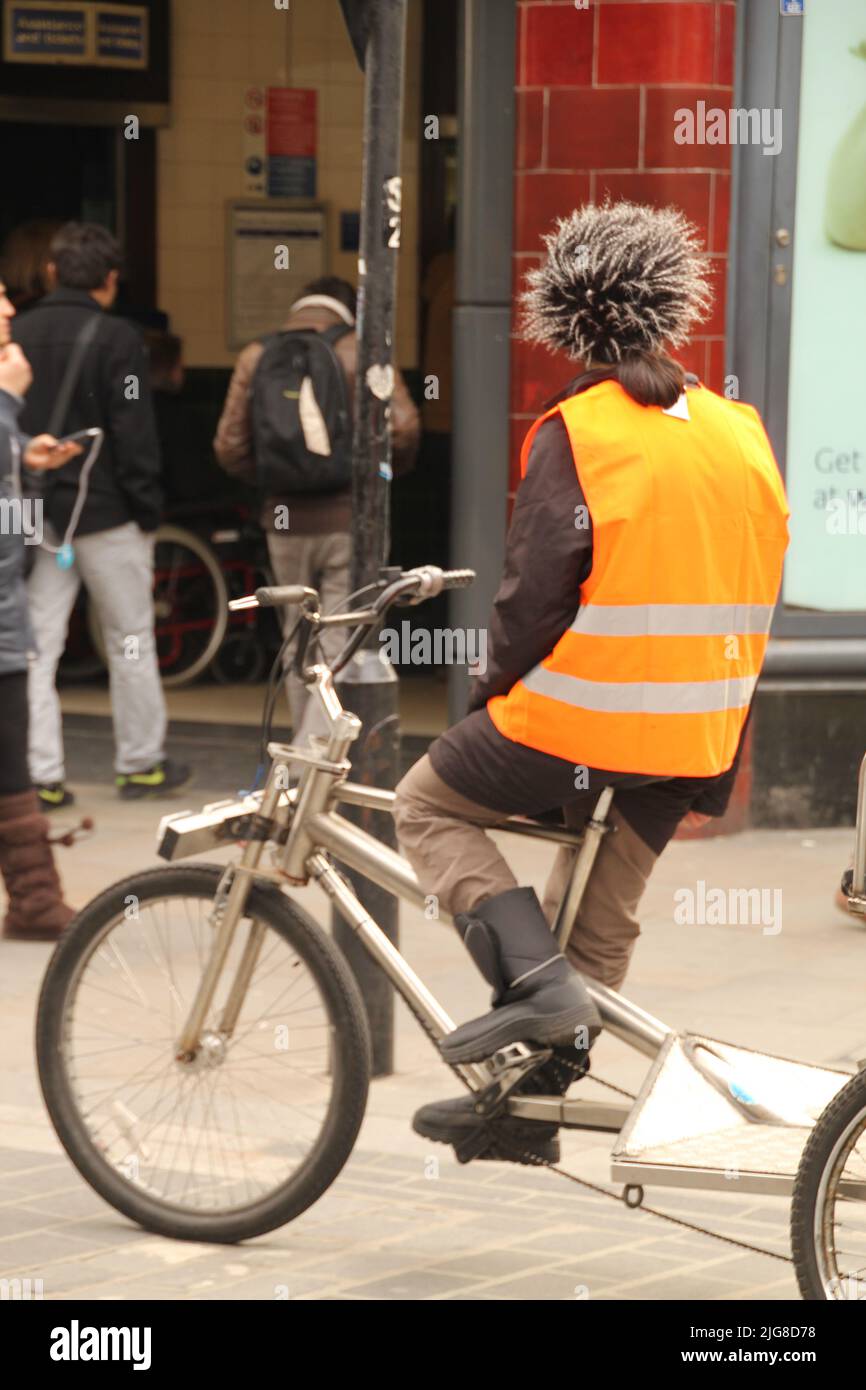 A back view of male with uniform sitting on bicycle in street Stock ...