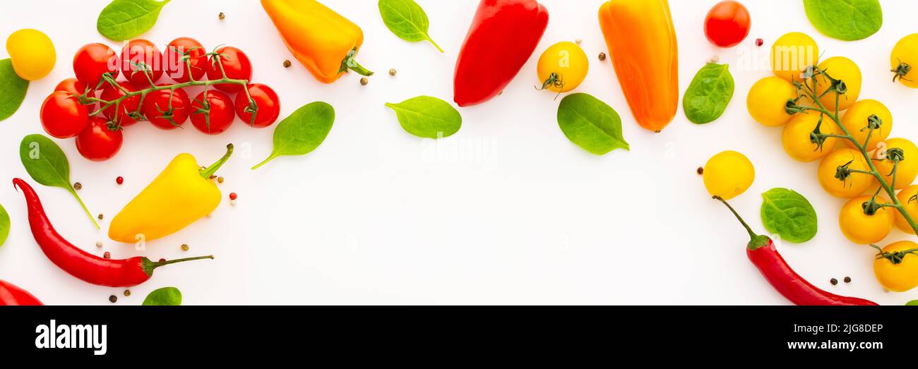 Yellow and red tomatoes, hot peppers,spinach and spices on a white ...