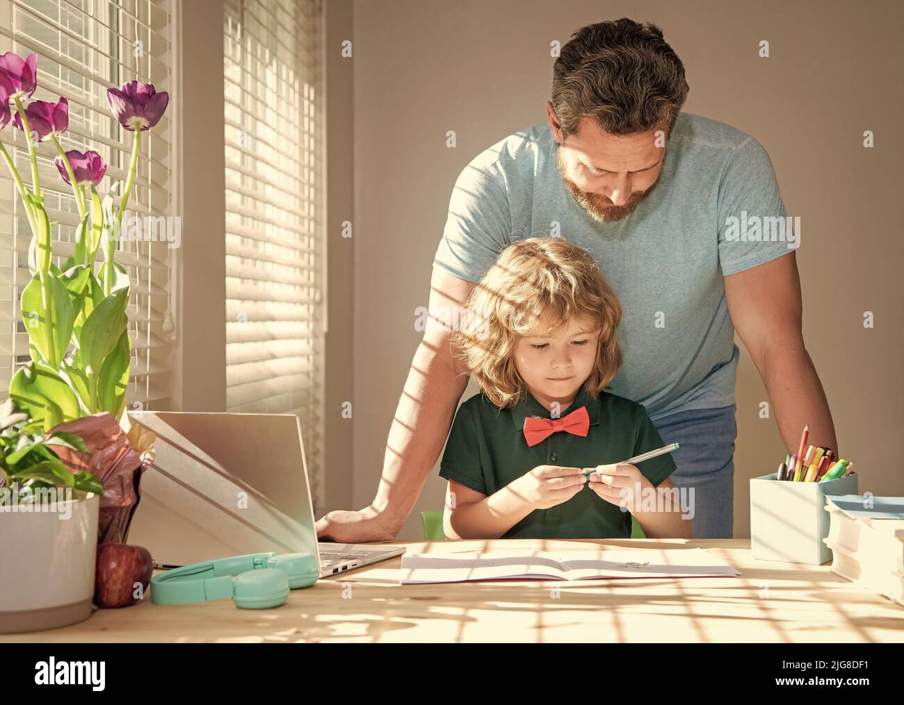 bearded daddy writing school homework with his child son in classroom ...