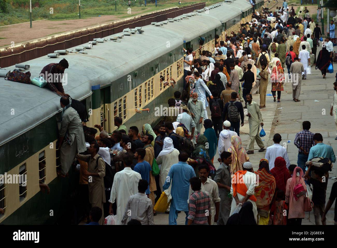 Pakistani people boarding on the roof top of a crowded train as they ...