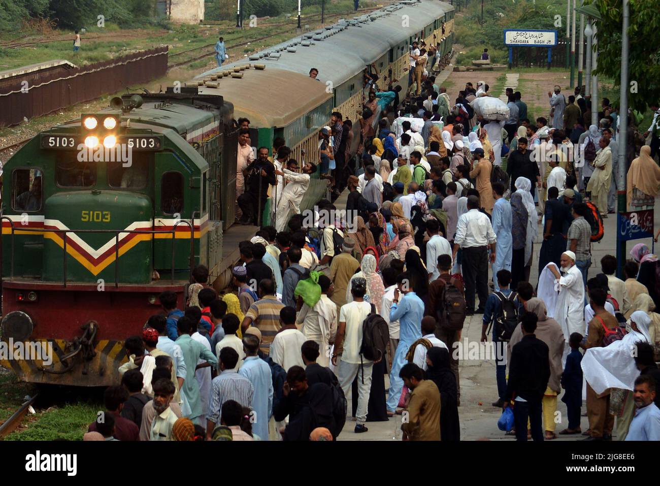 Pakistani people boarding on the roof top of a crowded train as they ...