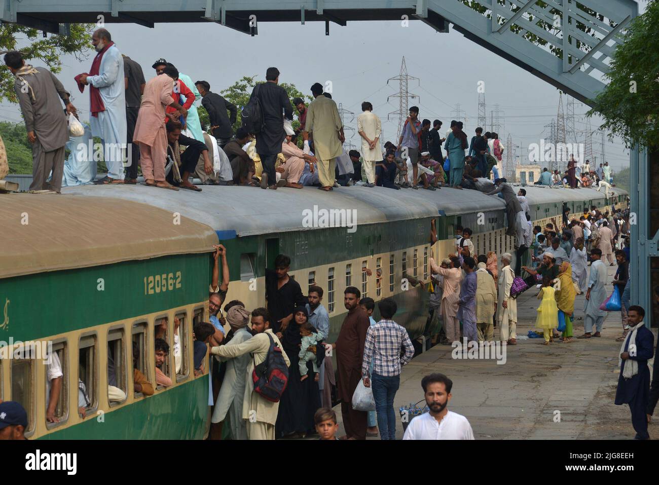 Pakistani people boarding on the roof top of a crowded train as they ...