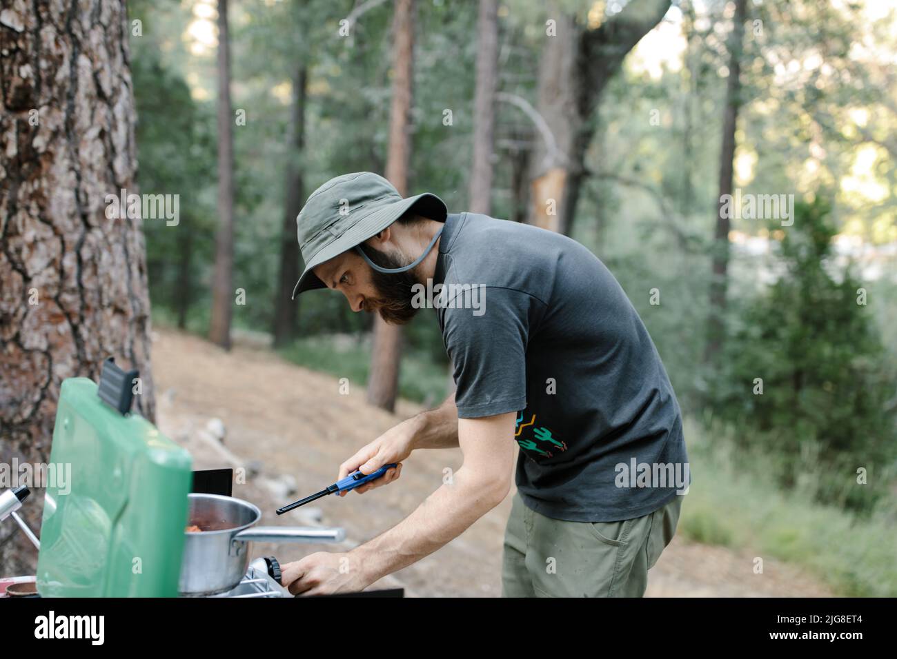 A Caucasian man cooking chili on a camp stove in the woods Stock Photo ...