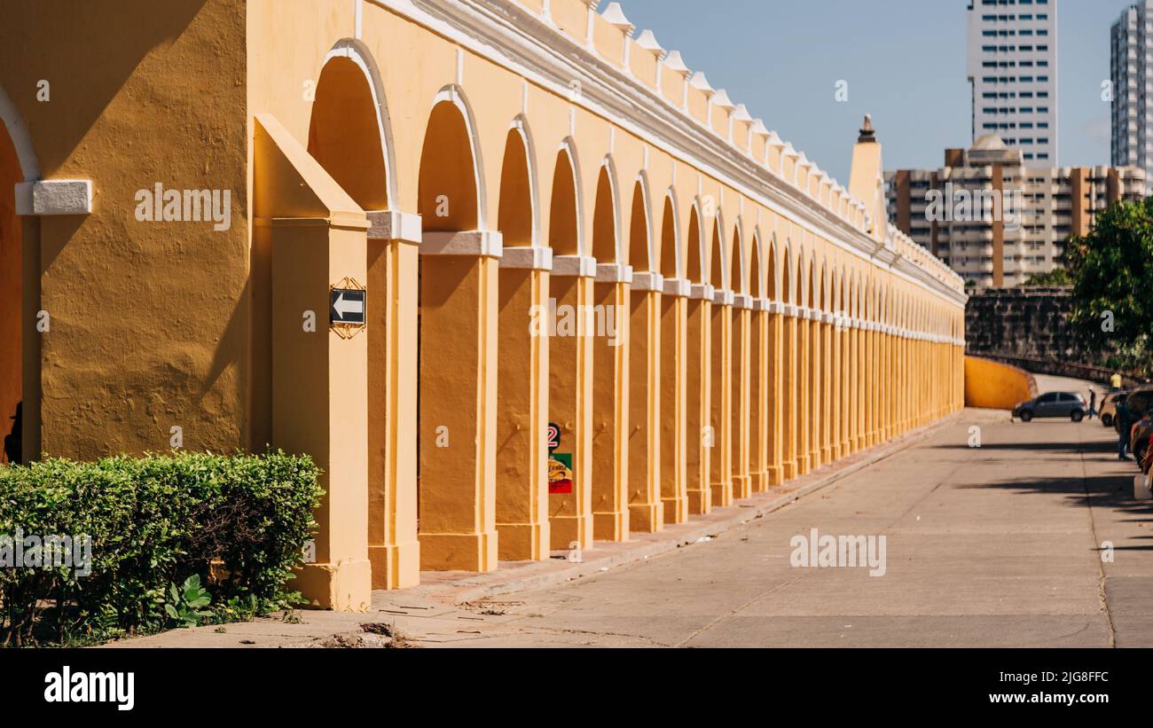 A historic long stone wall with yellow arches in Colombia Stock Photo ...