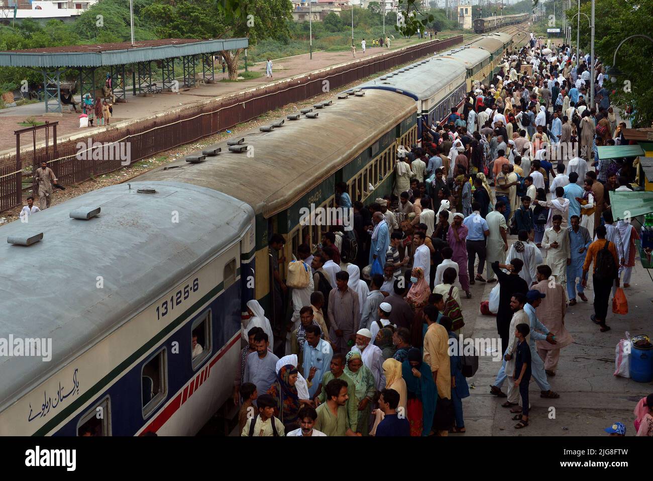 Pakistani people boarding on the roof top of a crowded train as they ...