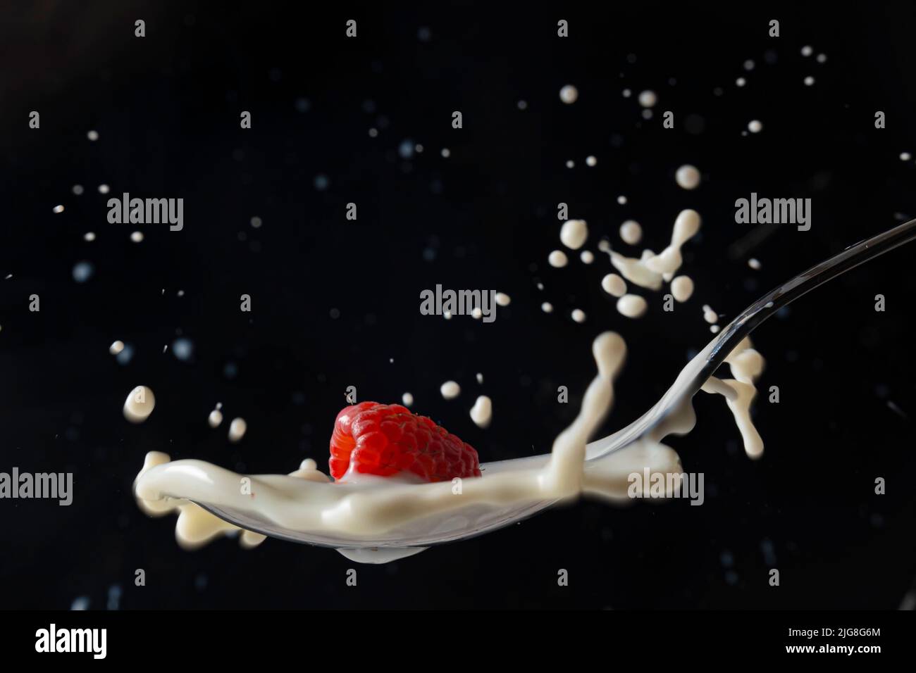 raspberry falls in milk splash Stock Photo - Alamy