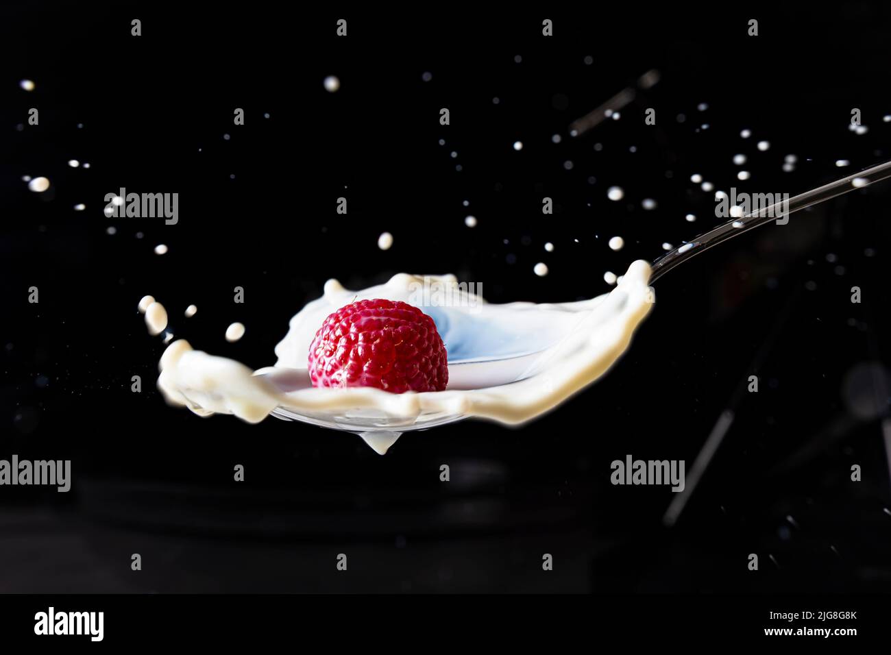 raspberry falls in milk splash Stock Photo - Alamy
