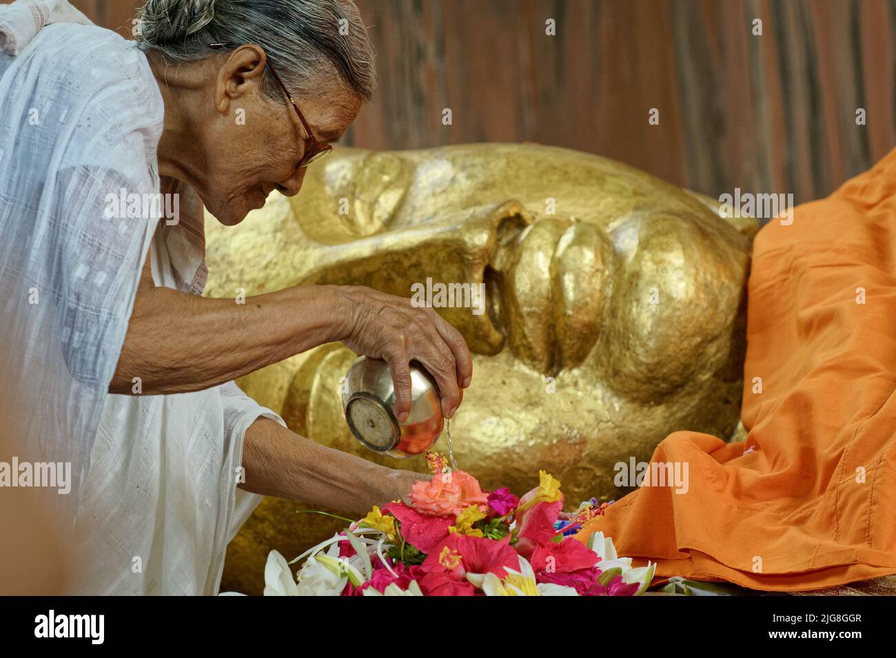08 28 2008 Devotees offering water and Flower to statue of lord buddha ...