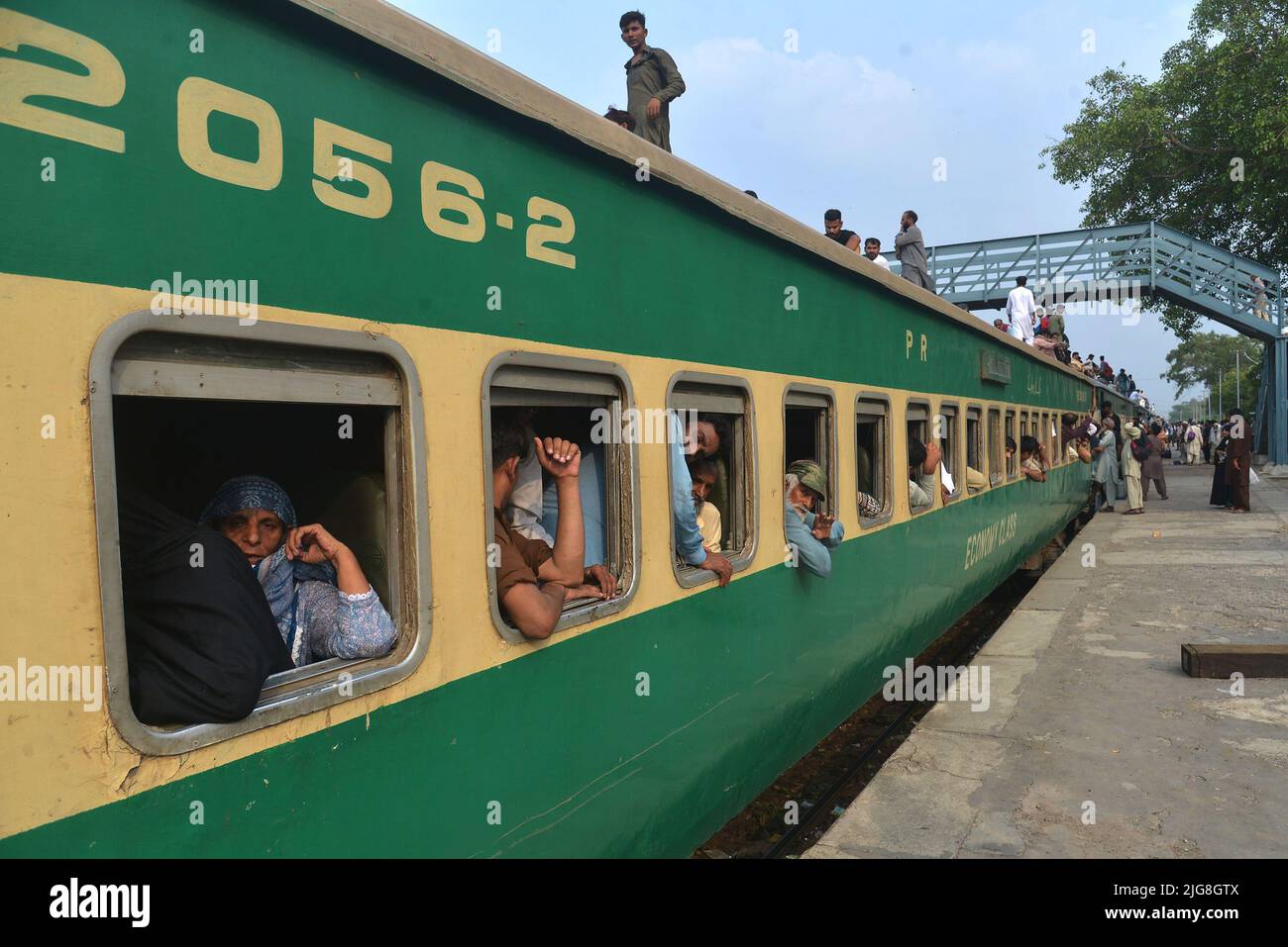 Pakistani people boarding on the roof top of a crowded train as they ...