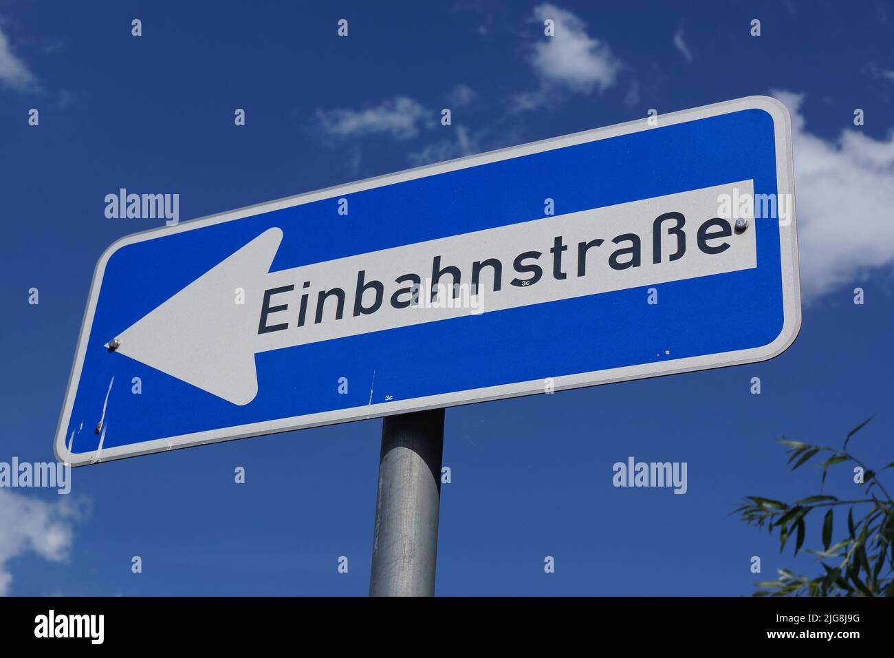 A traffic sign indicates a one-way street. Blue sign in front of blue ...