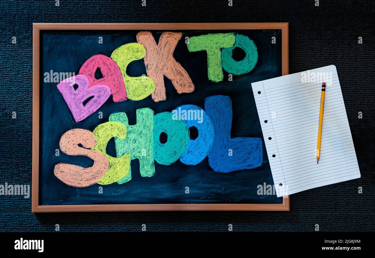 Back to school letters sign written on a chalkboard, paper and pencil ...