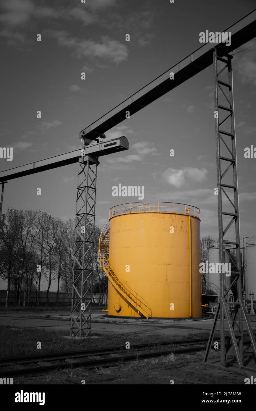 A yellow painted industrial storage tank in a grayscale shot Stock ...