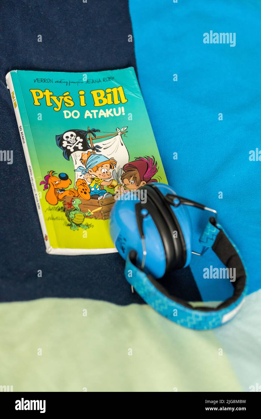 A vertical shot of a Polish comic book and a light blue ear protection ...