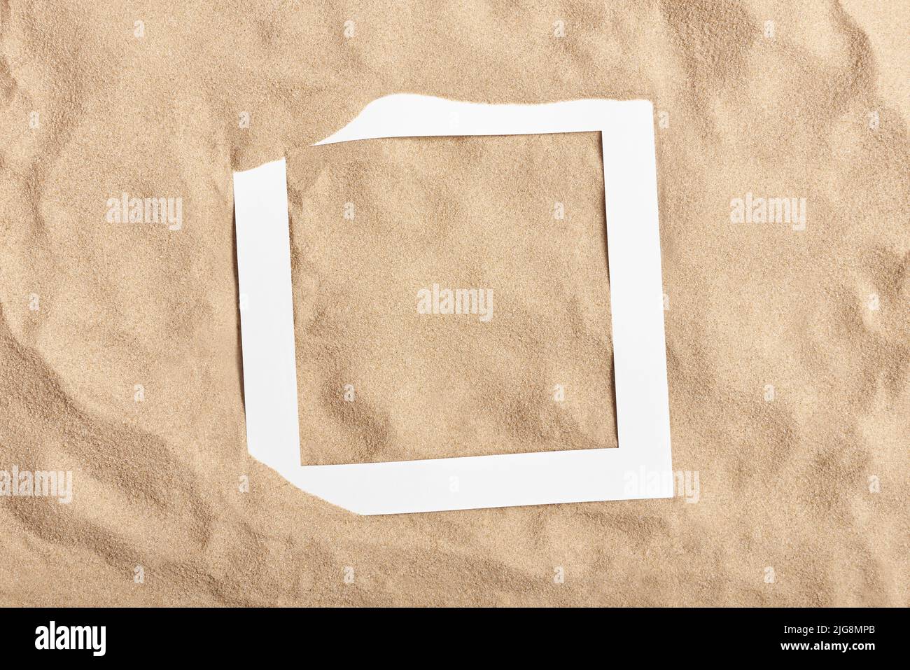 Summer layout, top view of beach sand with an empty white paper frame ...