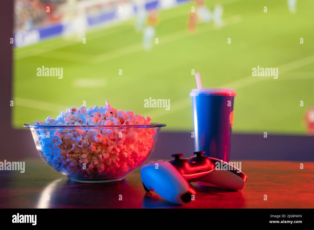 Football match on big screen TV. Popcorn, drink and joystick. Sports ...
