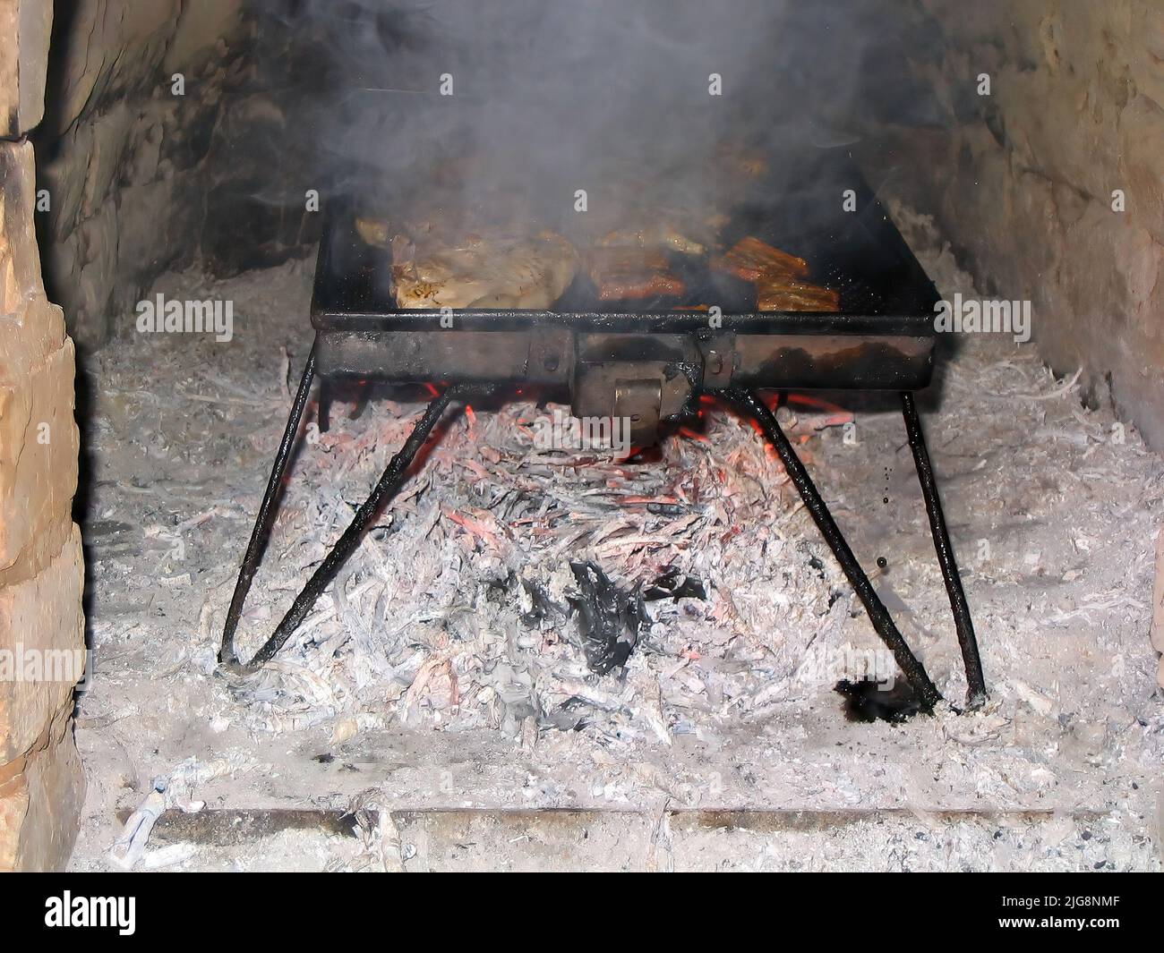 Preparing a barbecue roasting meat on a charcoal flame Stock Photo - Alamy