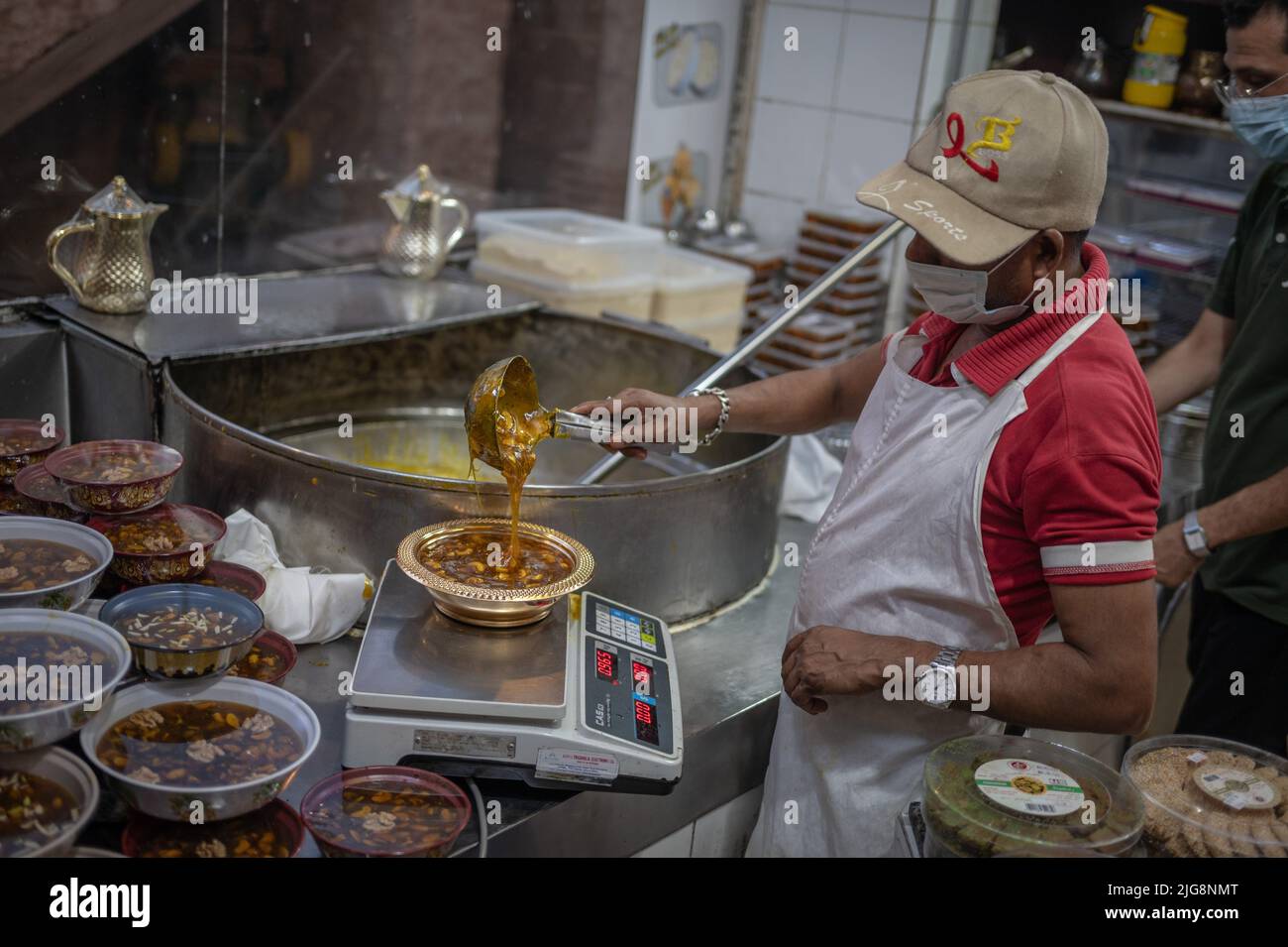 Doha, Qatar. 08th July, 2022. An employee of a candy store pours liquid ...