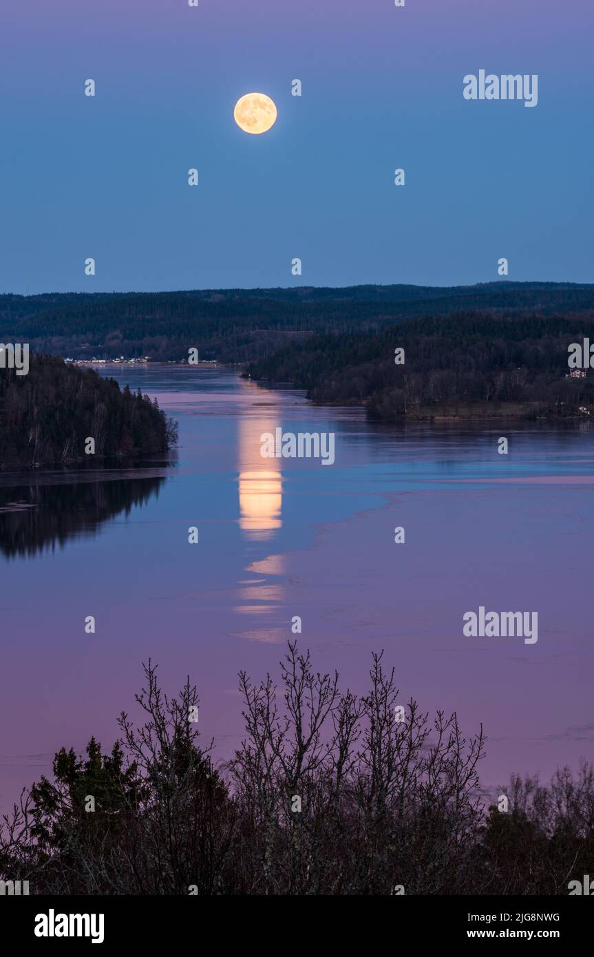 Full moon over a lake in western Sweden Stock Photo - Alamy