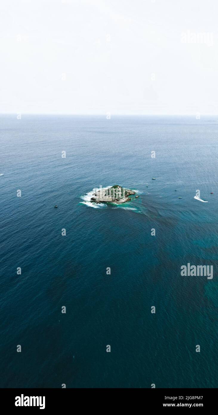 A vertical high-angle shot of a little island in the middle of the ...