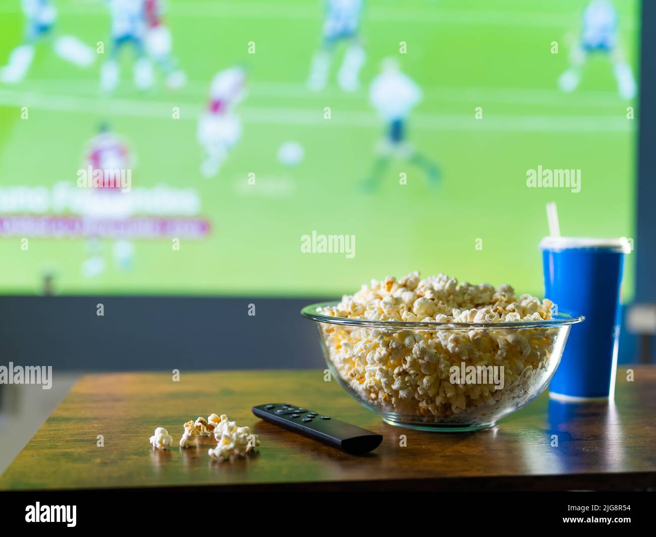 The traditional set of a sports fan - popcorn in a glass bowl, a ...